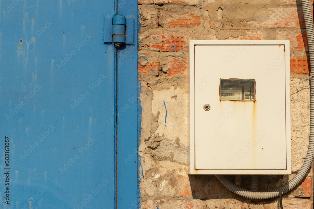 Foto de Closed electric meter on the old brick wall of the garage do ...