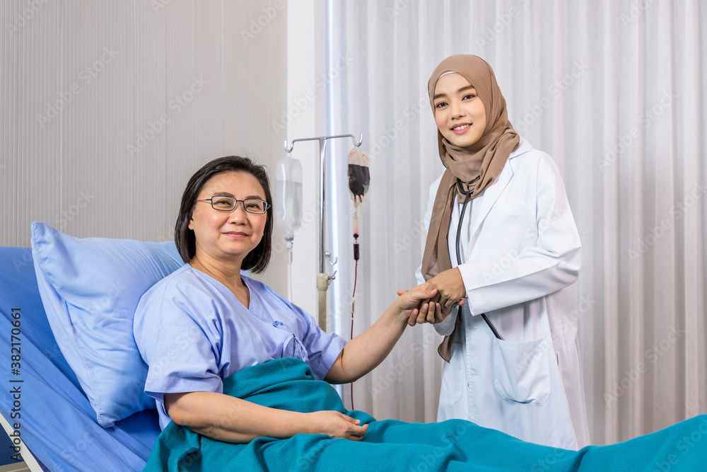 Muslim female woman medical doctor examining patient who lying on bed ...