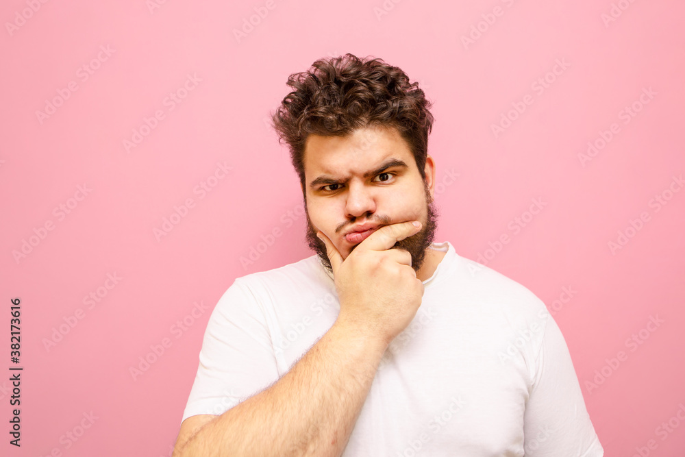 Funny fat man in white t-shirt looks into camera with pensive serious ...
