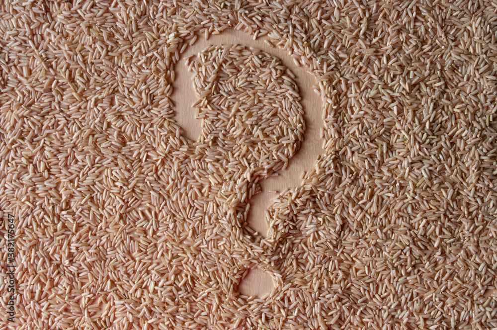 question mark sign ? on a brown rice background on plywood Stock Photo ...