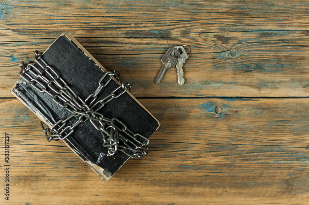 Old book bound by a new shiny chain and key on dark background. Stock ...