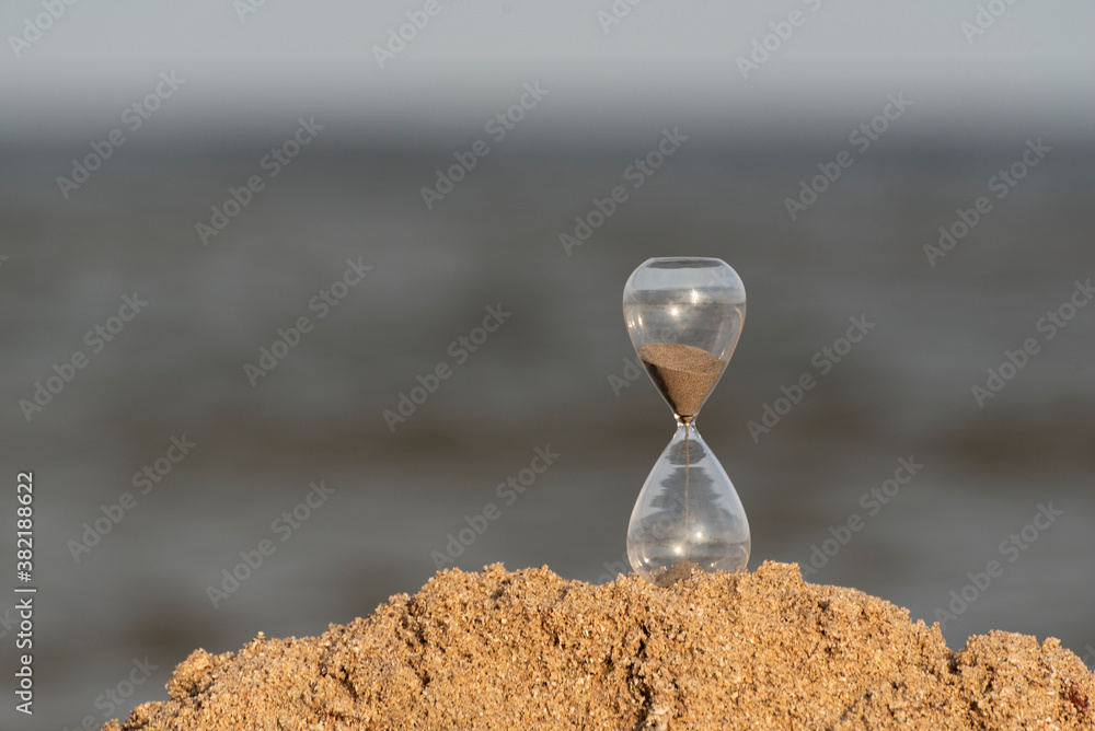 Hourglass in sand on sea background. Time concept Stock Photo | Adobe Stock