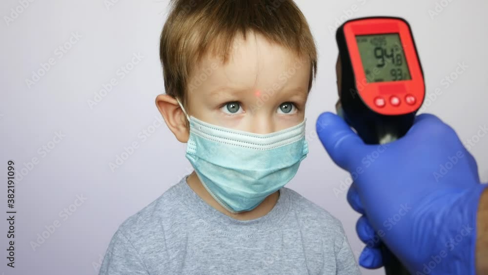 A measuring the boys temperature using a digital thermometer and then ...
