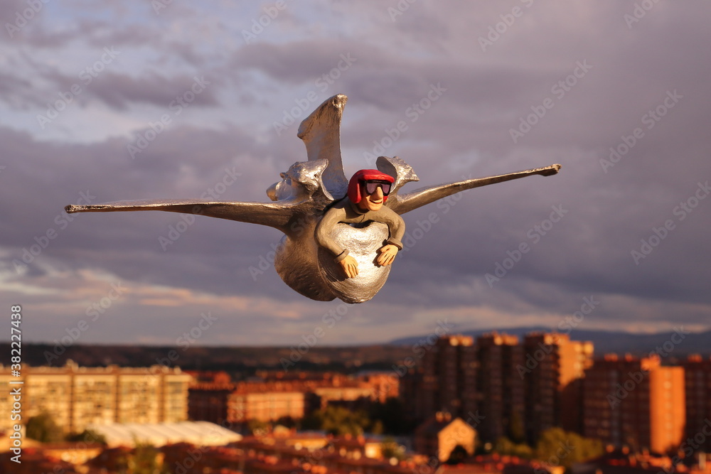 PILOT FLYING OVER A CITY ON A SILVER COW VERTEBRA AT SUNSET Stock Photo ...