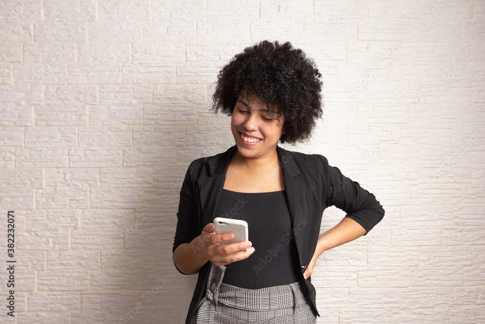 Young black woman with afro hairstyle checking smart cell phone and ...