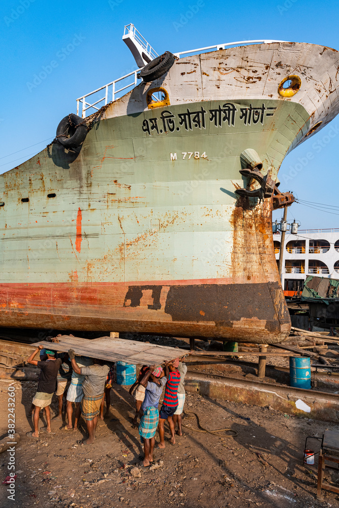 Foto de Men carrying a very heavy metal plate to the river, shipwreck ...