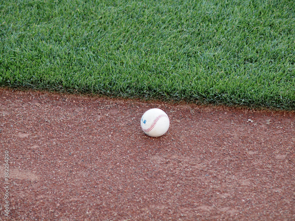 Baseball rest on edge of warning track beyond the outfield grass Stock ...