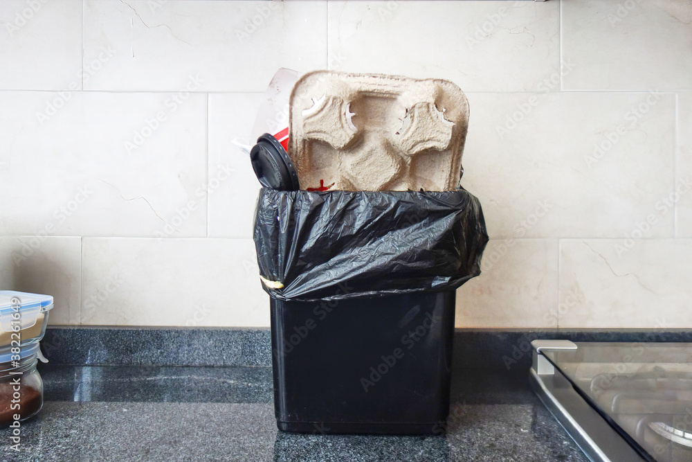 Full trash bin in a kitchen Stock Photo | Adobe Stock
