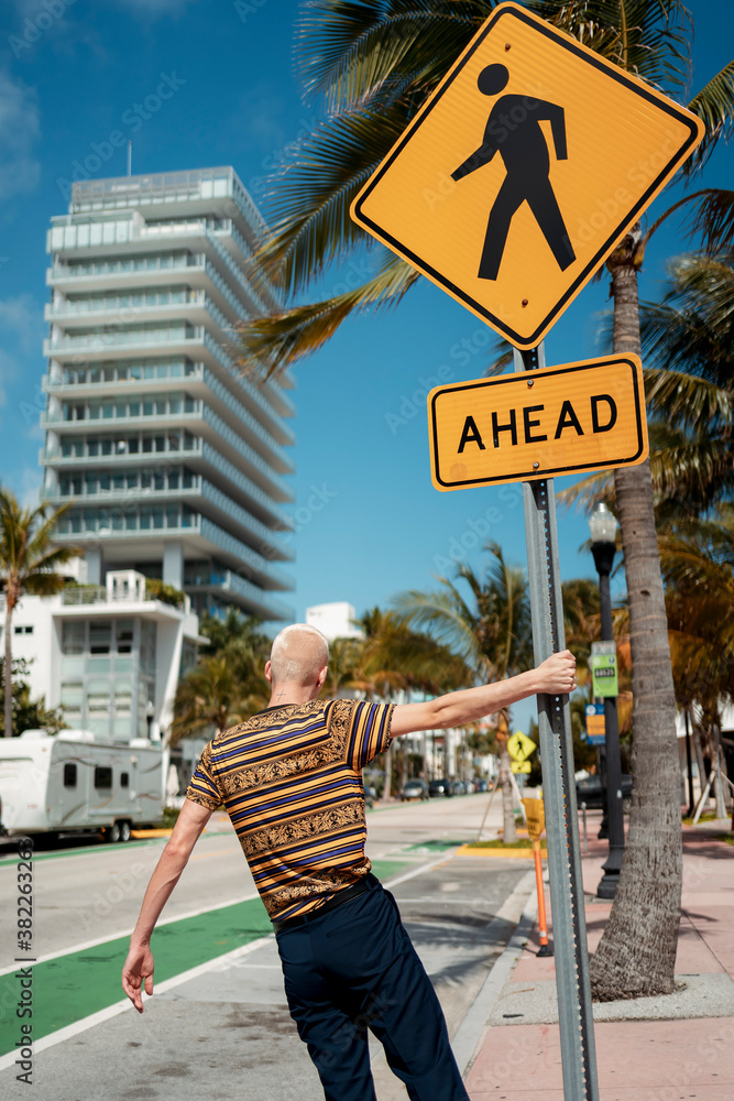 Stylish blond man playing outdoor with road signs Stock Photo | Adobe Stock
