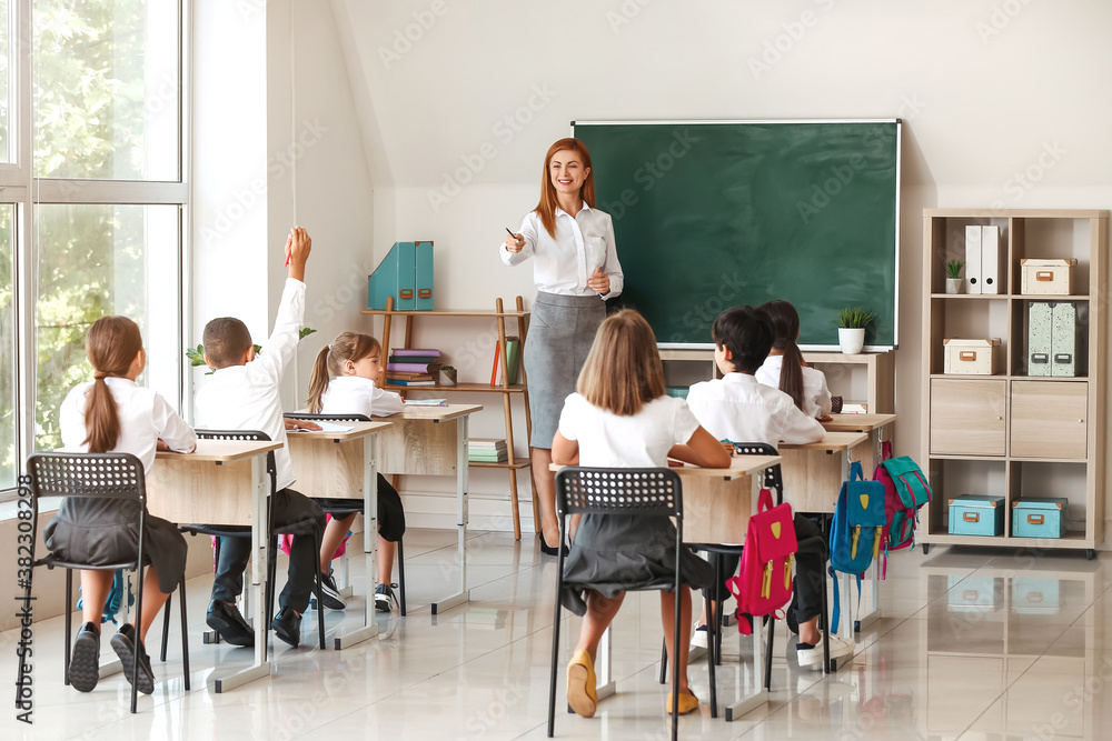 Teacher conducting lesson in classroom Stock Photo | Adobe Stock