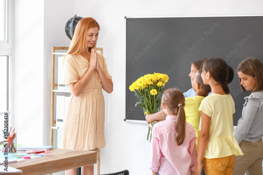 Schoolchildren greeting their teacher in classroom Stock Photo | Adobe ...