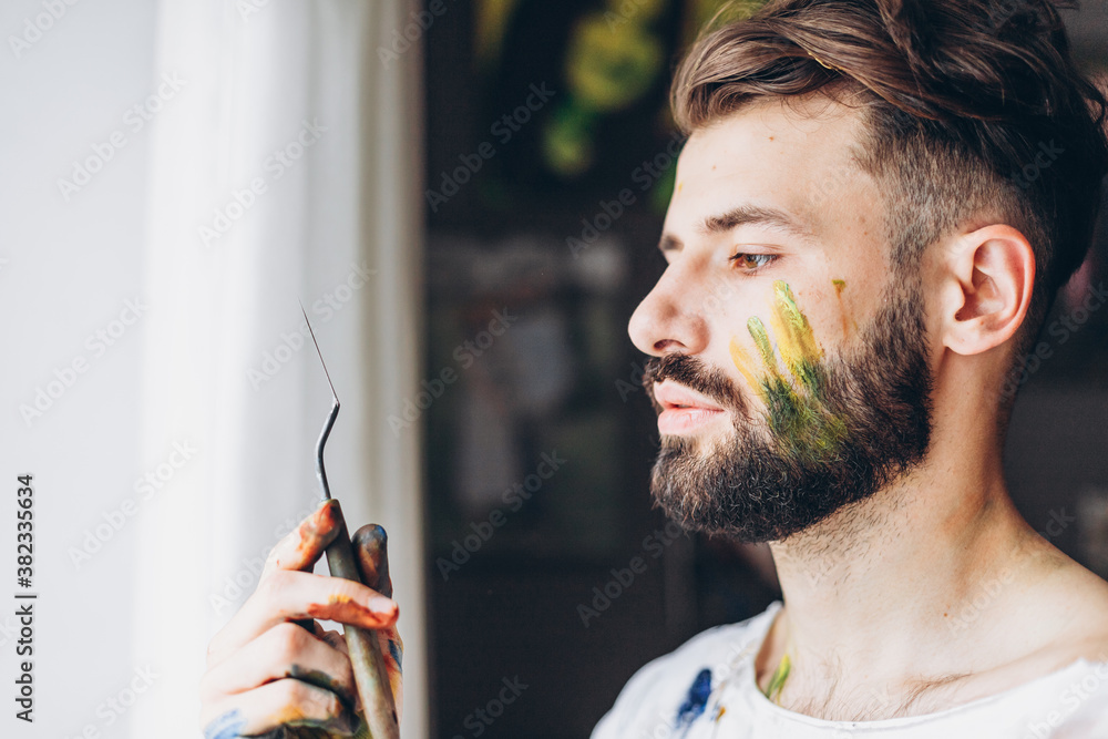 Young creative man who is fond of drawing poses for a photo in his ...