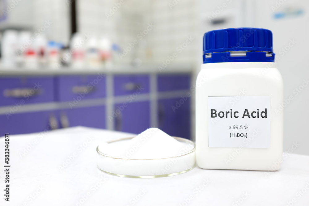 Selective focus of a bottle of pure boric acid chemical compound beside ...