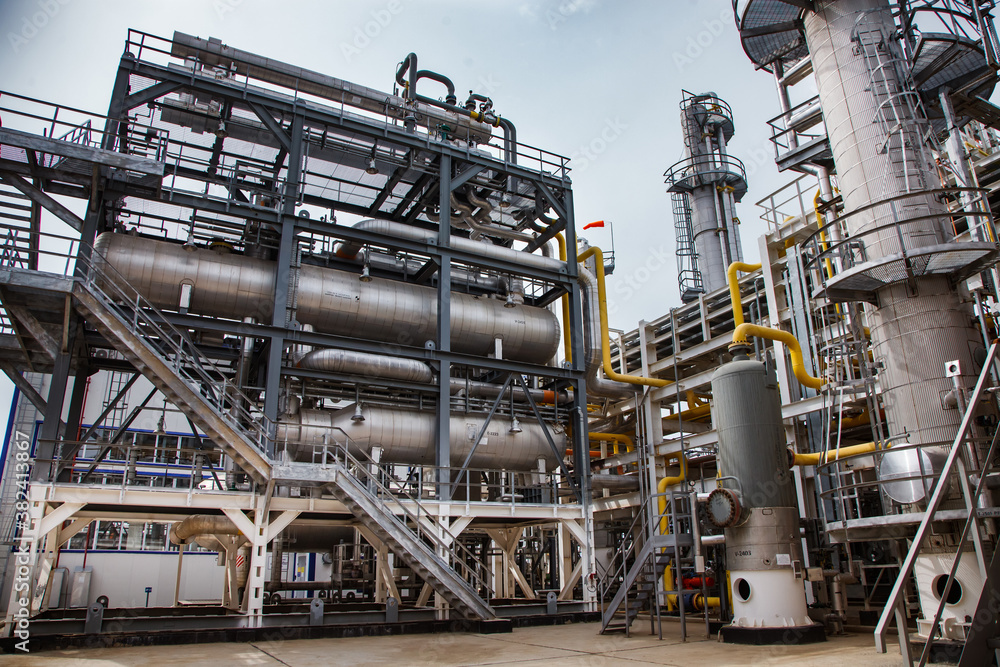 Oil refinery and gas processing plant. Grey metal distillation tower ...