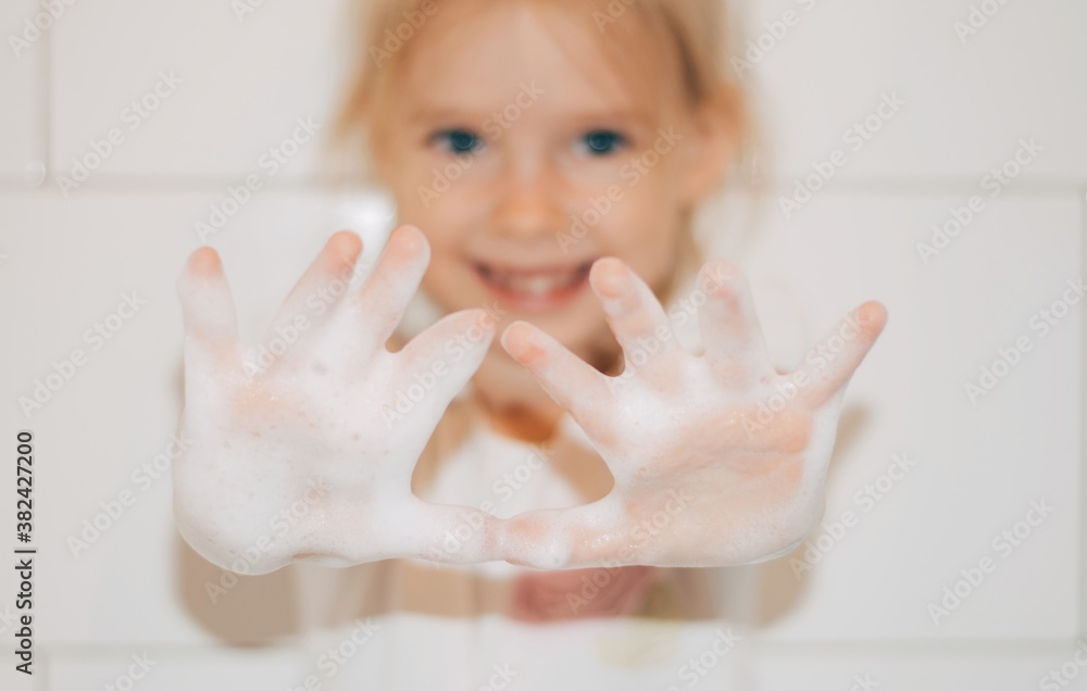 Smilling little girl is washing hands. Cute child showing soapy hands ...