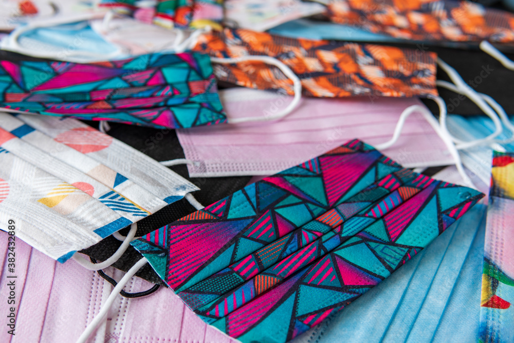 A stack / pile of disposable colorful medical face masks (surgical ...