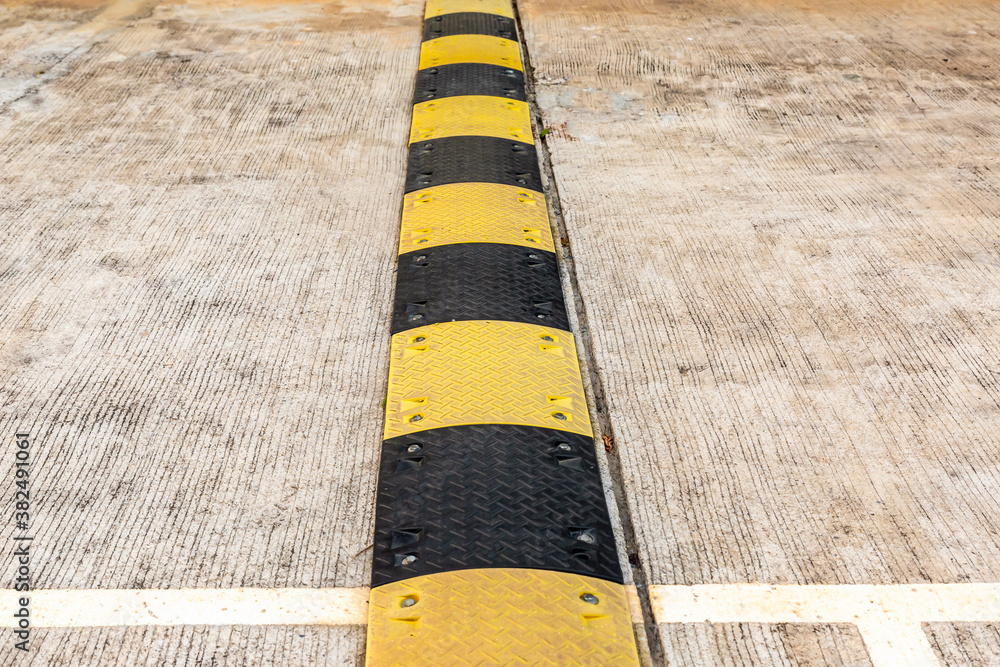 black and yellow striped road bumps installed in front of a pedestrian ...