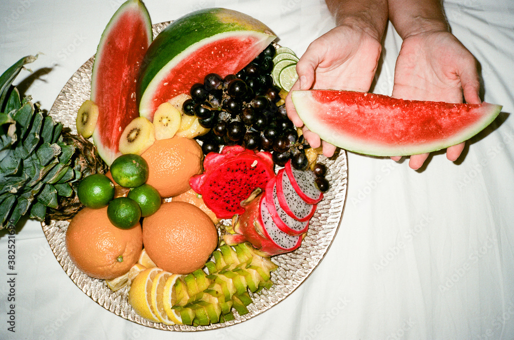 female legs crossed on bed eating fruit from giant tray compilation of ...