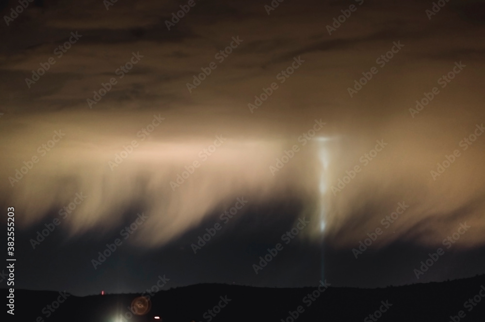 Light from the luxor reflects on rain clouds falling from the night sky ...