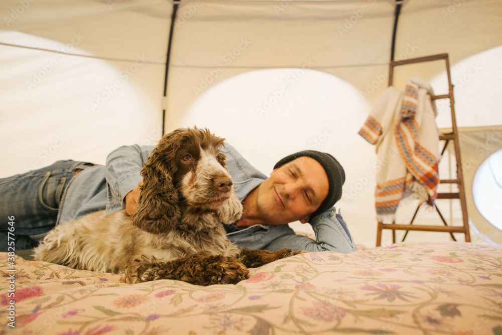 Glamping - Caucasian Man Stroking Cocker Spaniel on Bed Inside Large ...