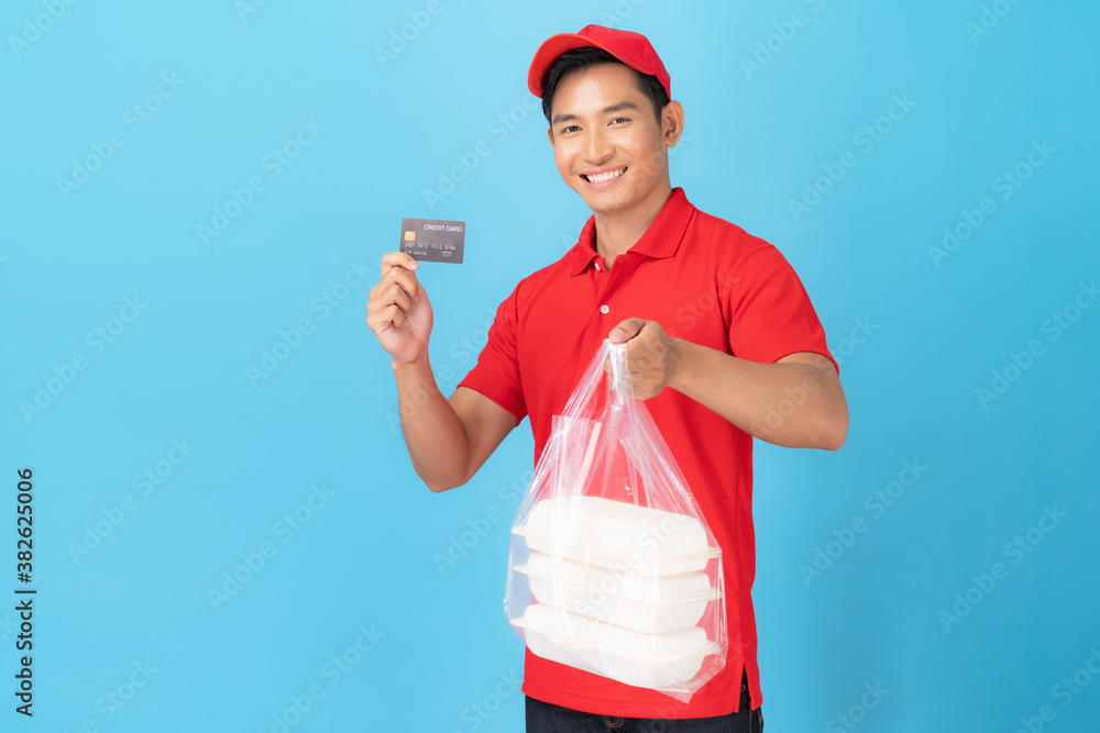 Smiling delivery man employee in red cap blank shirt uniform standing ...