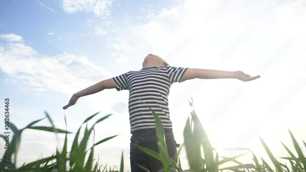 boy prays pulls hands to the sky against a blue sky. child concept ...