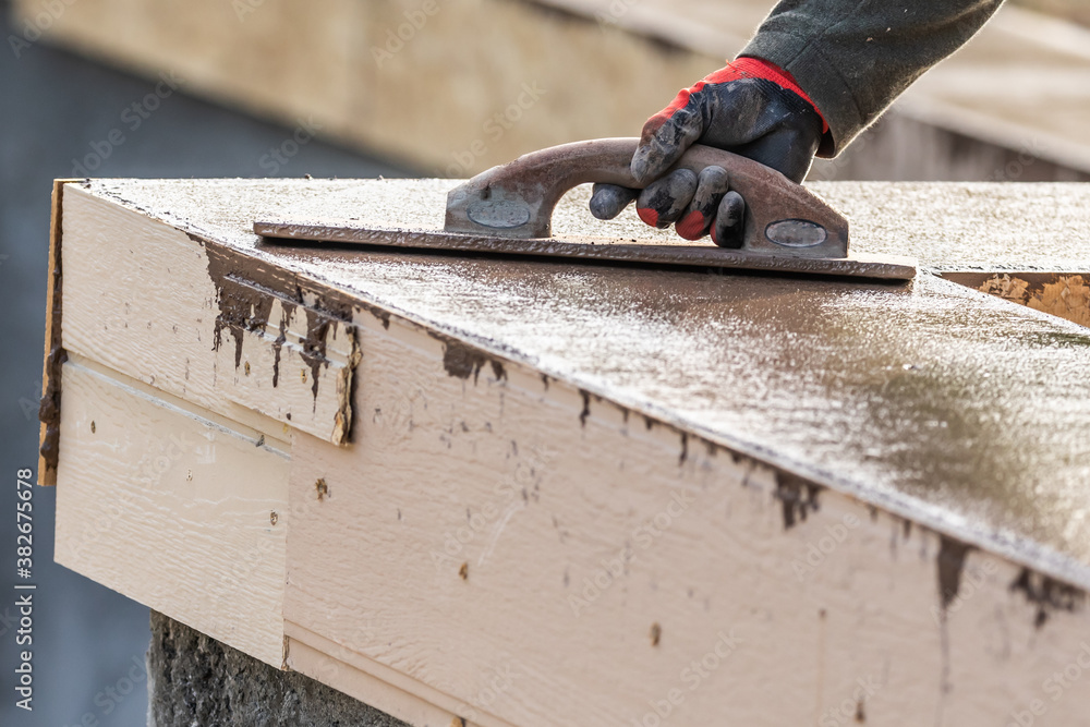 Construction Worker Using Wood Trowel On Wet Cement Forming Coping ...