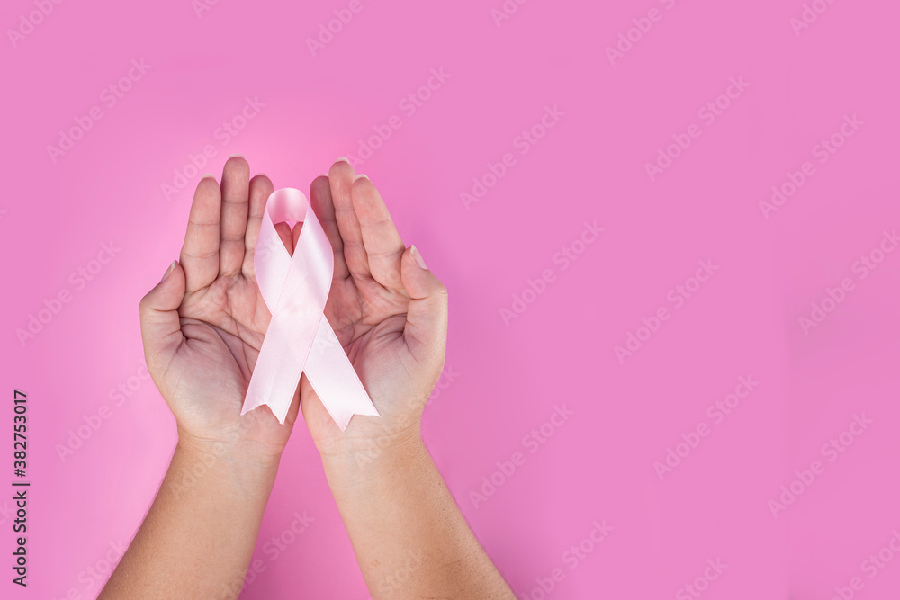 fondo rosado liso y una mano con lazo rosado del cáncer de mama Stock ...