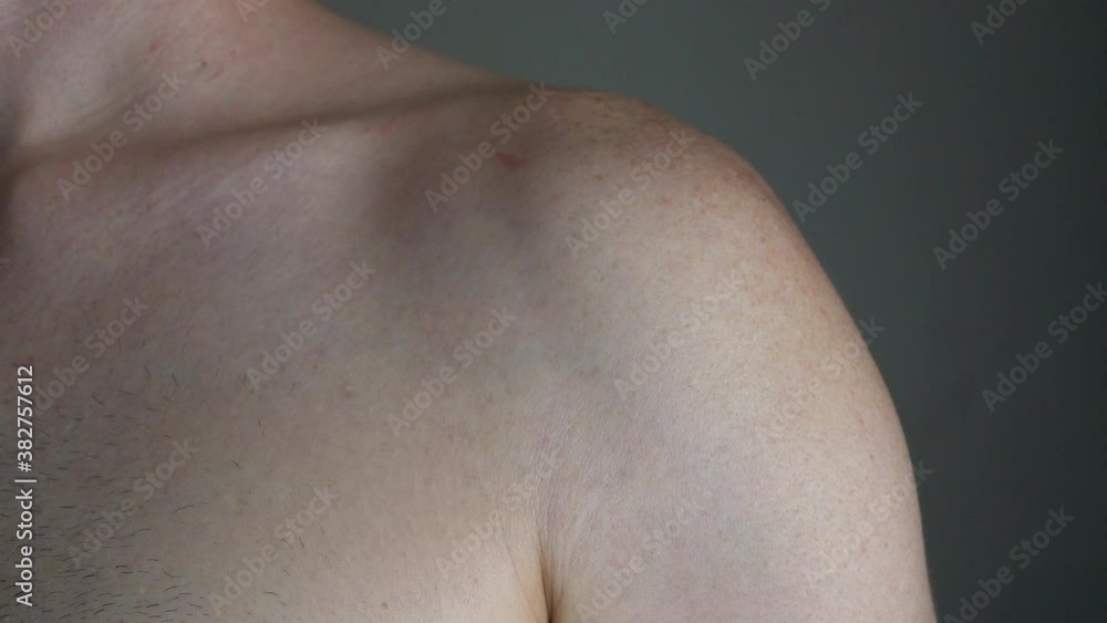 A nerve involuntarily and repeatedly twitches in a man's shoulder and ...