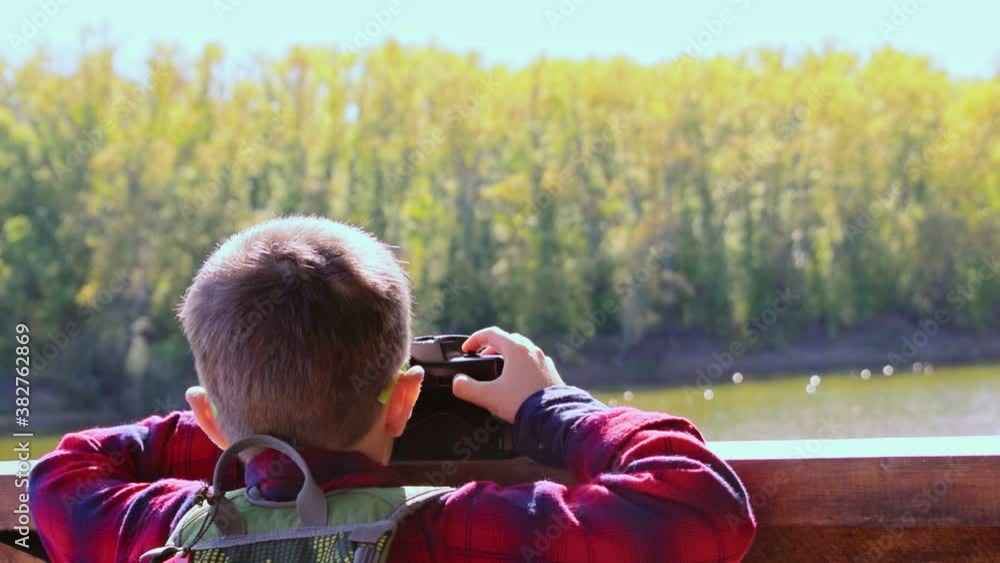 Video Stock A cute schoolboy with a camera takes a picture of the ...