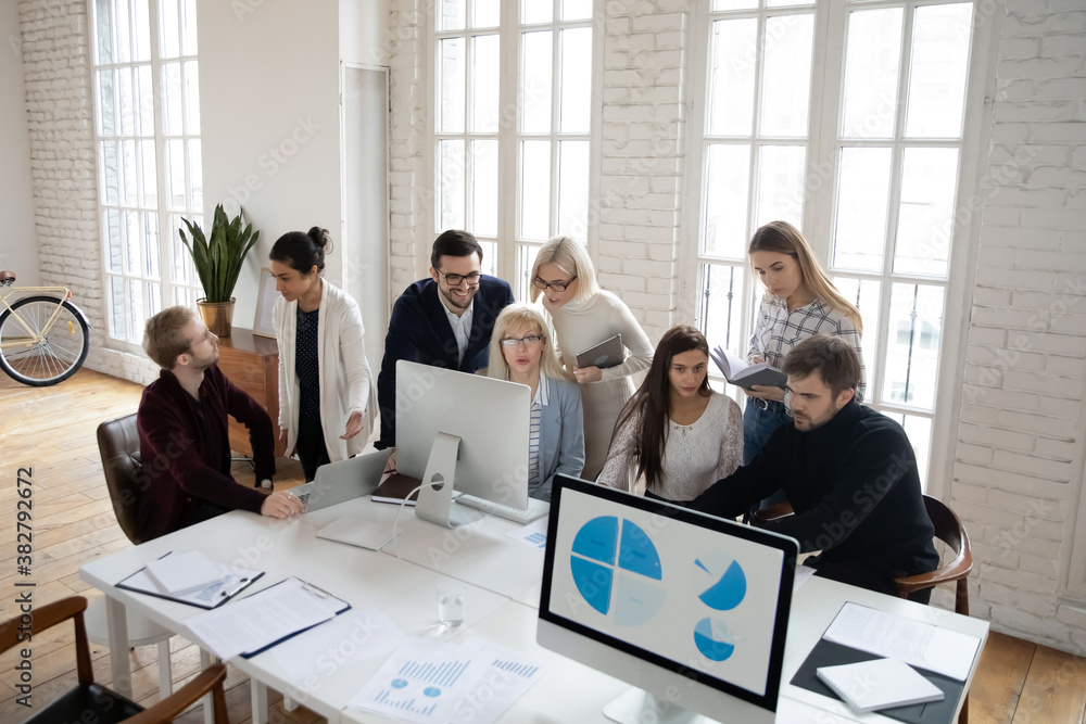 Top view of diverse multiethnic colleagues sit at desk in shared office ...