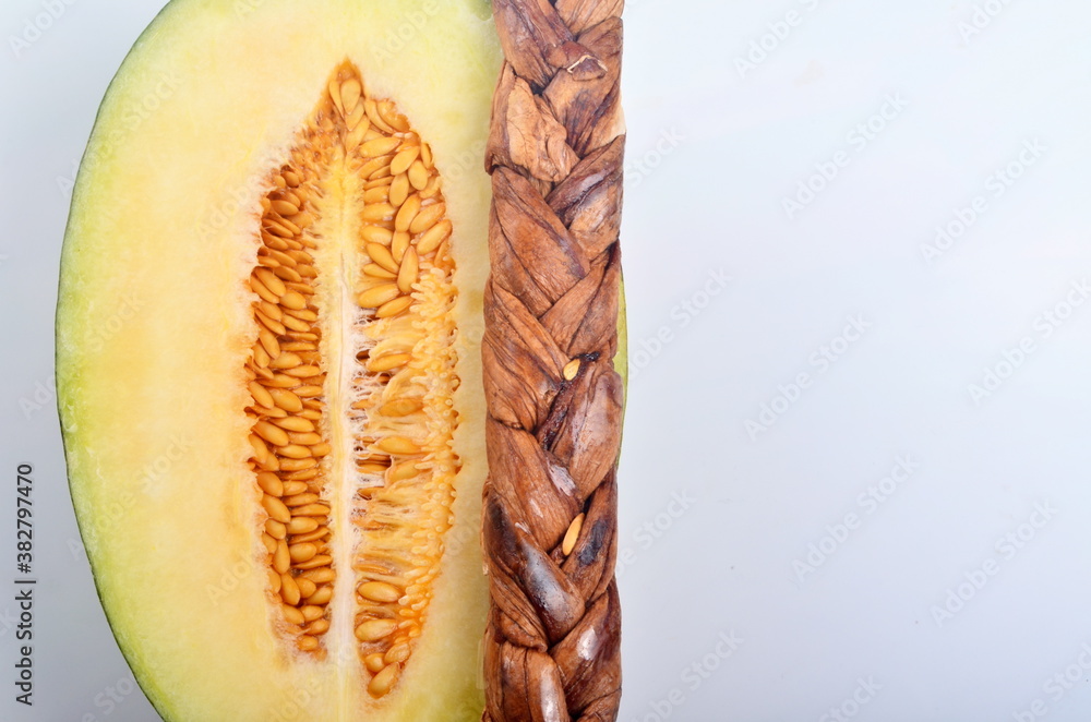 Dried melon in the form of plait on cut melons isolated on white ...