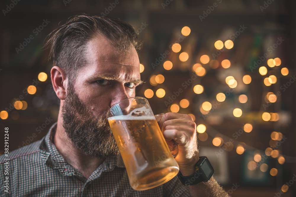 Young hipster looking man drinking beer out of a glass on a party ...
