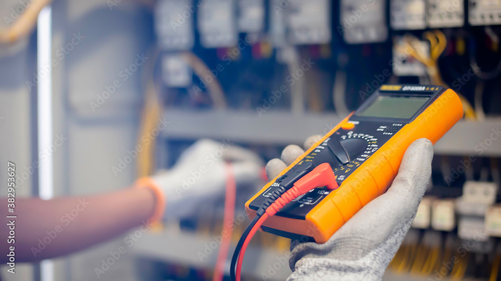 Electrician engineer uses a multimeter to test the electrical ...