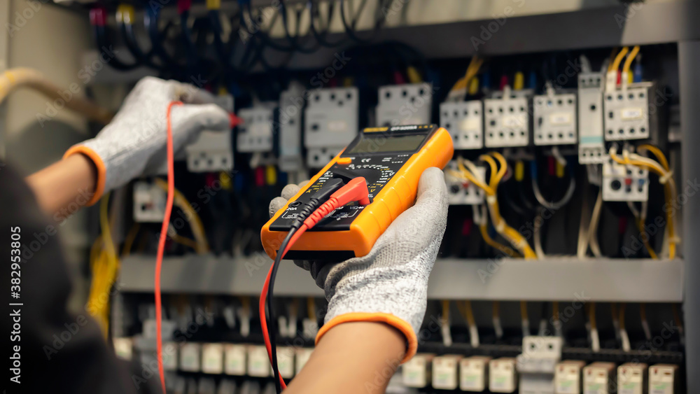 Electrician engineer uses a multimeter to test the electrical ...