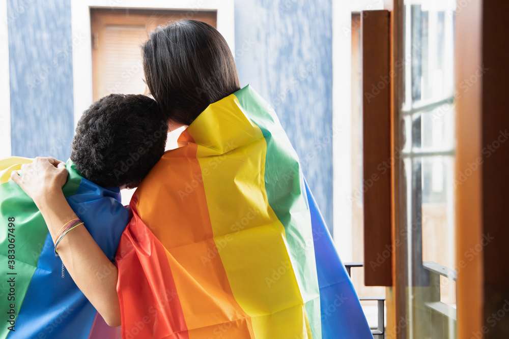 Black African LGBT woman covering LGBTQ rainbow flag with asian LGBT ...