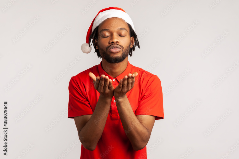 Positive handsome afro-american man with beard and dreadlocks in santa ...