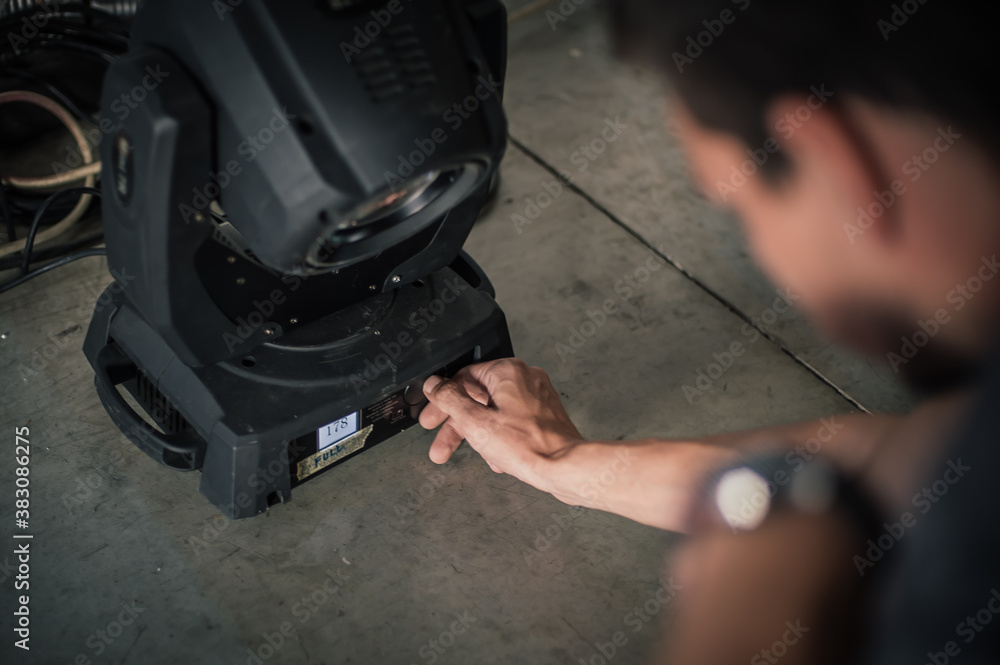 Theater lighting technician electric engineer adjusting focus of ...
