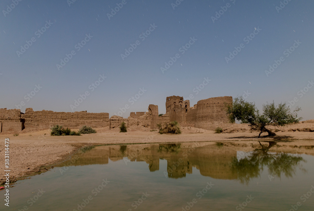 reflection of an old fort in calm water of pond in the desert, moujgarh ...