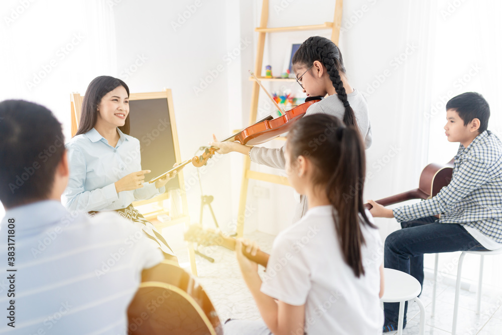 cute asian children holding violin on her shoulder and play violin, she ...
