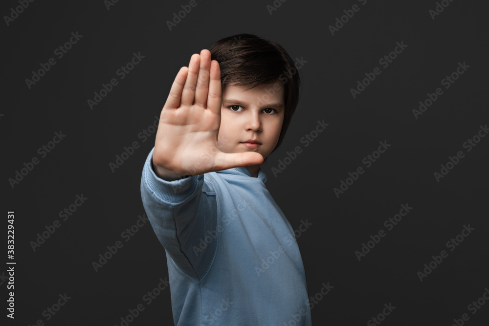 Image of serious boy doing stop sign with palm of the hand. Warning ...