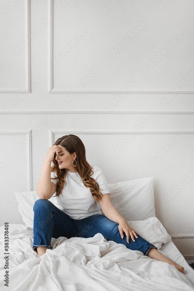 Plus-size model girl in jeans and blank white t-shirt sitting on the ...