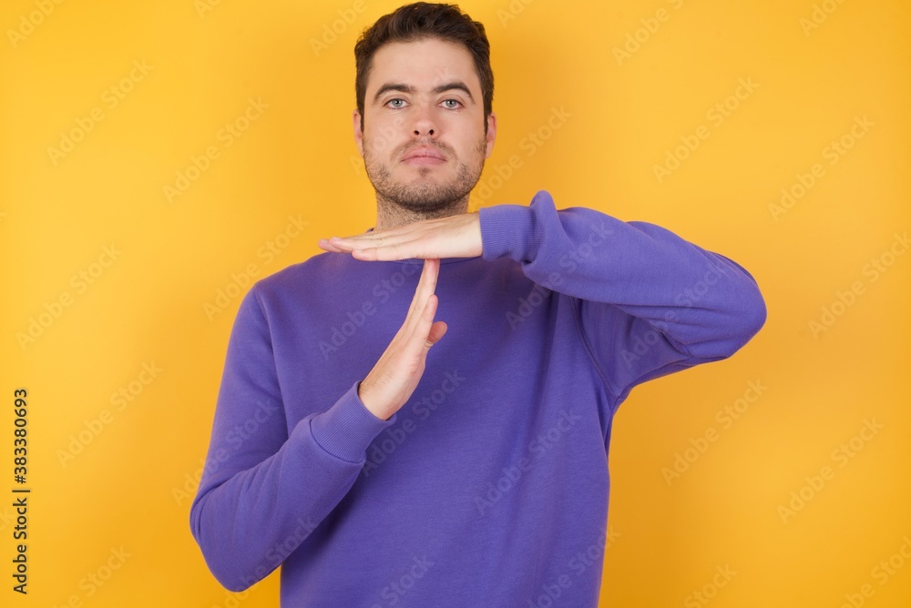 Handsome man with sweatshirt over isolated yellow background being ...