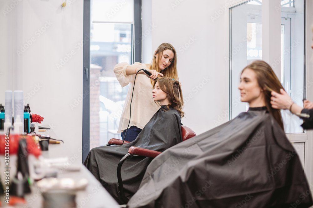 beauty, hairstyle concept, happy young woman and hairdresser with hair ...