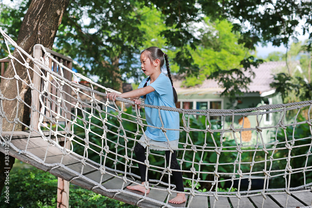 Asian little child girl playing on suspension wooden bridge. Kid ...