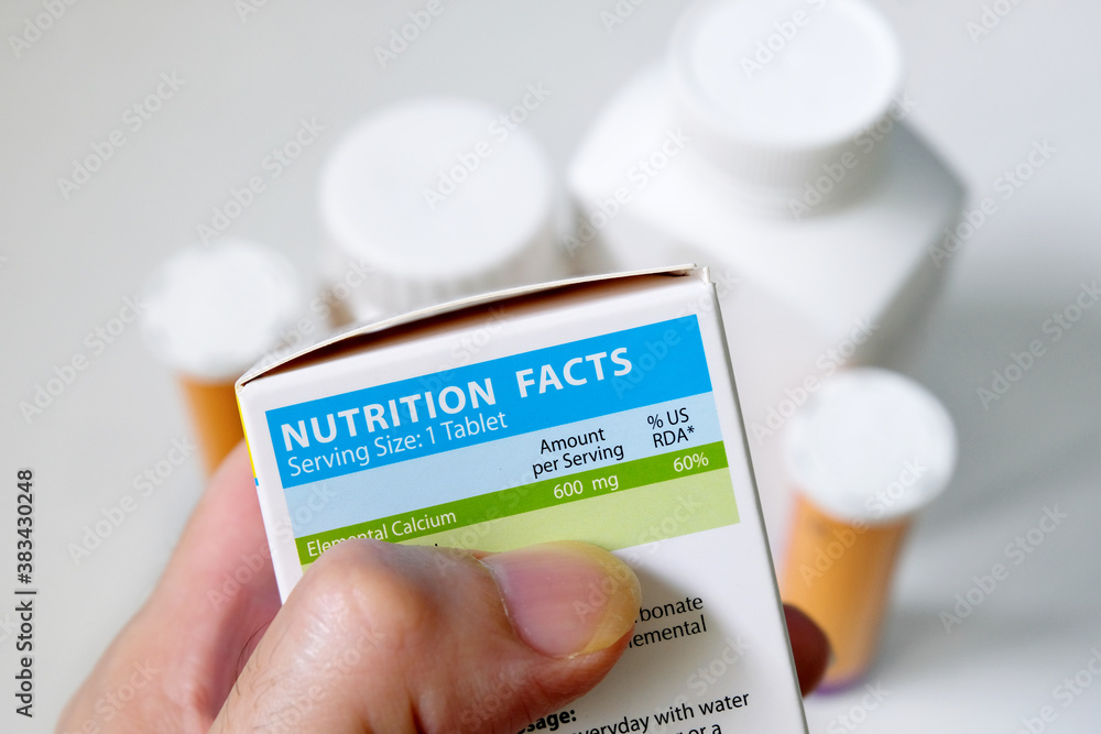 Hand holding a mineral supplement box to read and know more on the ...