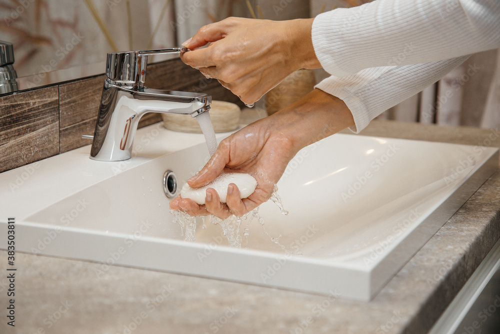 washing hands under warm running water with germicidal soap to prevent ...