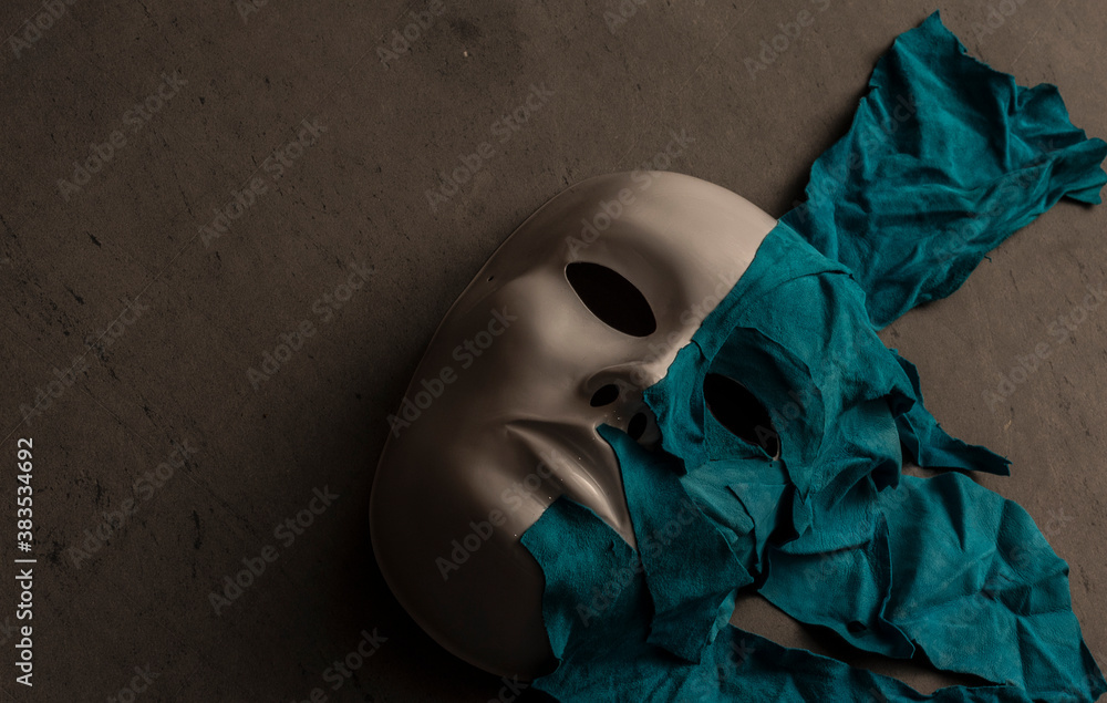 White theater mask on a black background covered with leather flaps ...