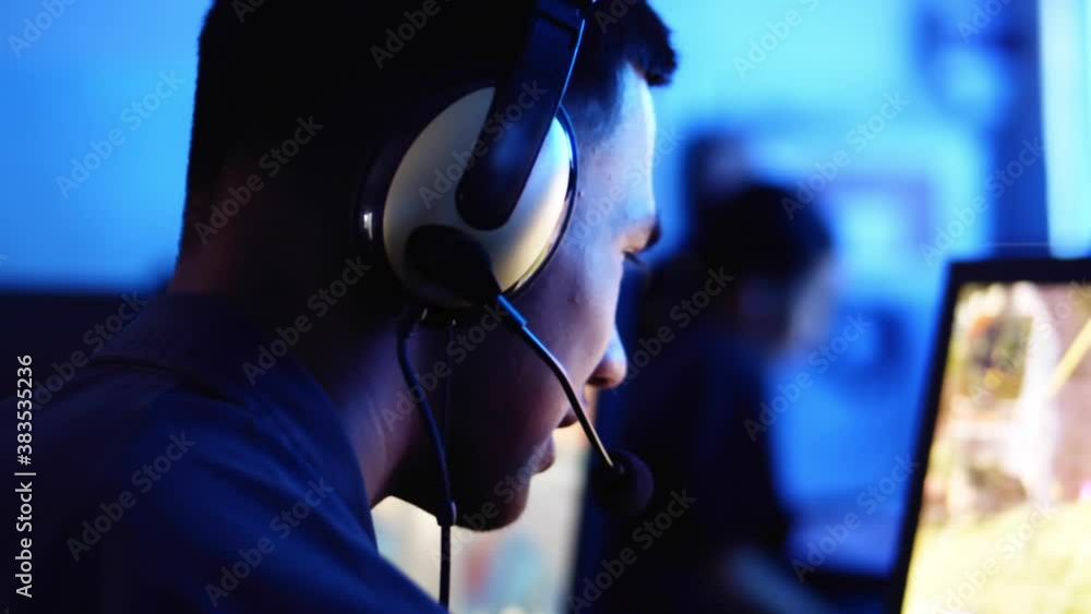 Male gamer with headset is playing online games in an exciting battle ...