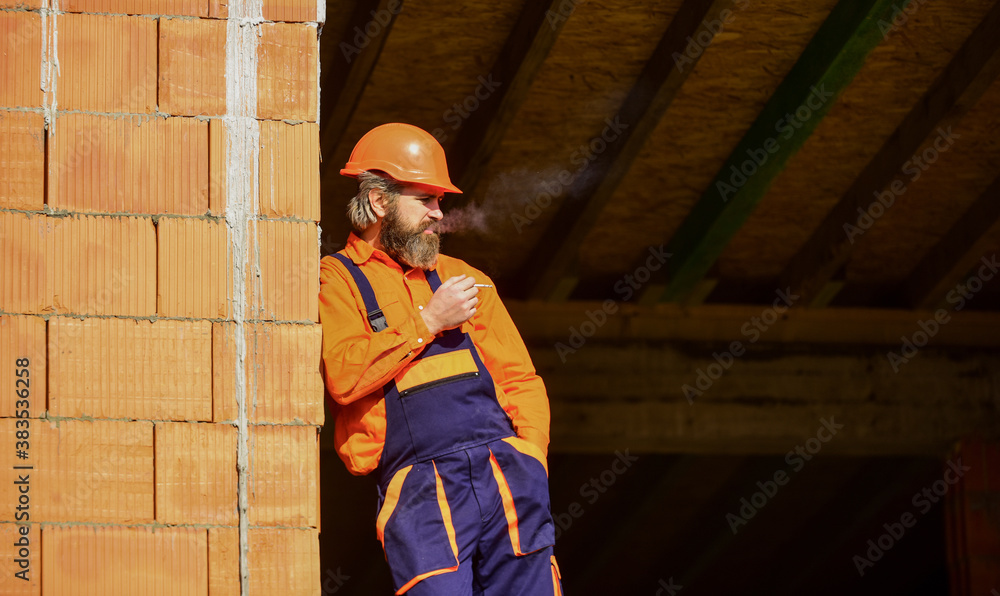 construction worker smoking cigarette. building is under construction ...